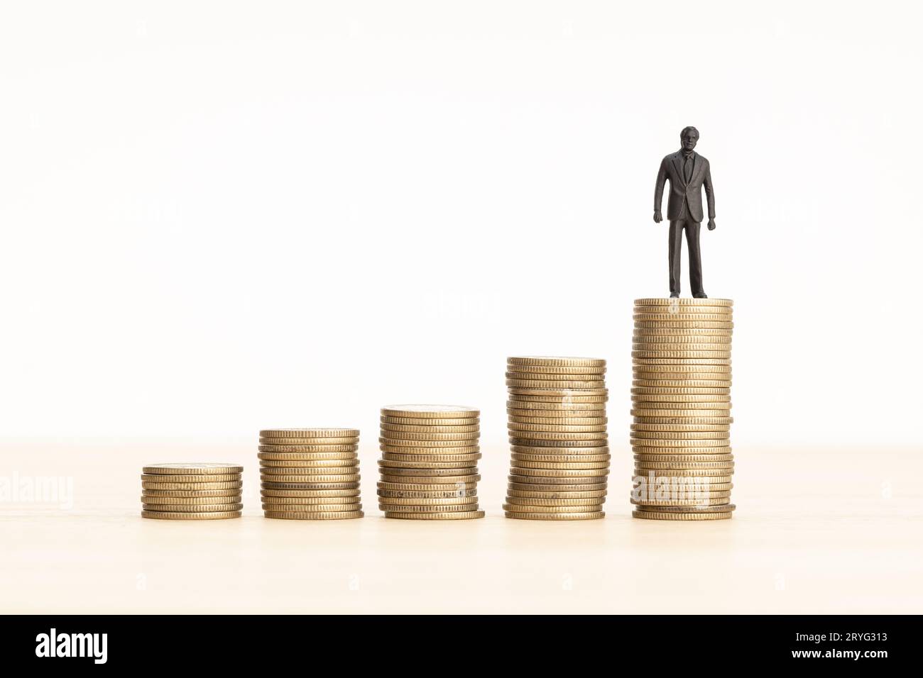 Wealth growth process concept. Man figurine on Rising Coin stacks. Copy ...