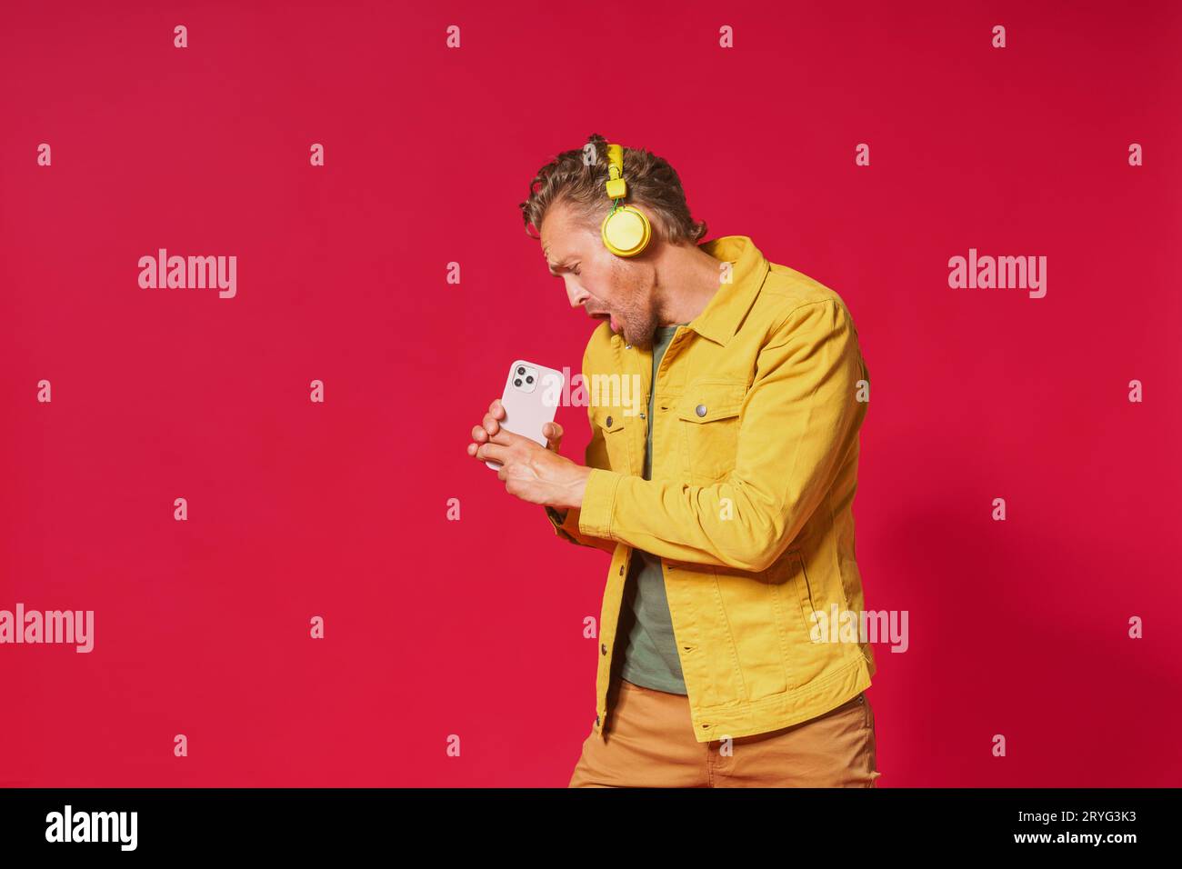Joyful man sing while recording his voice using smartphone. Singing ...
