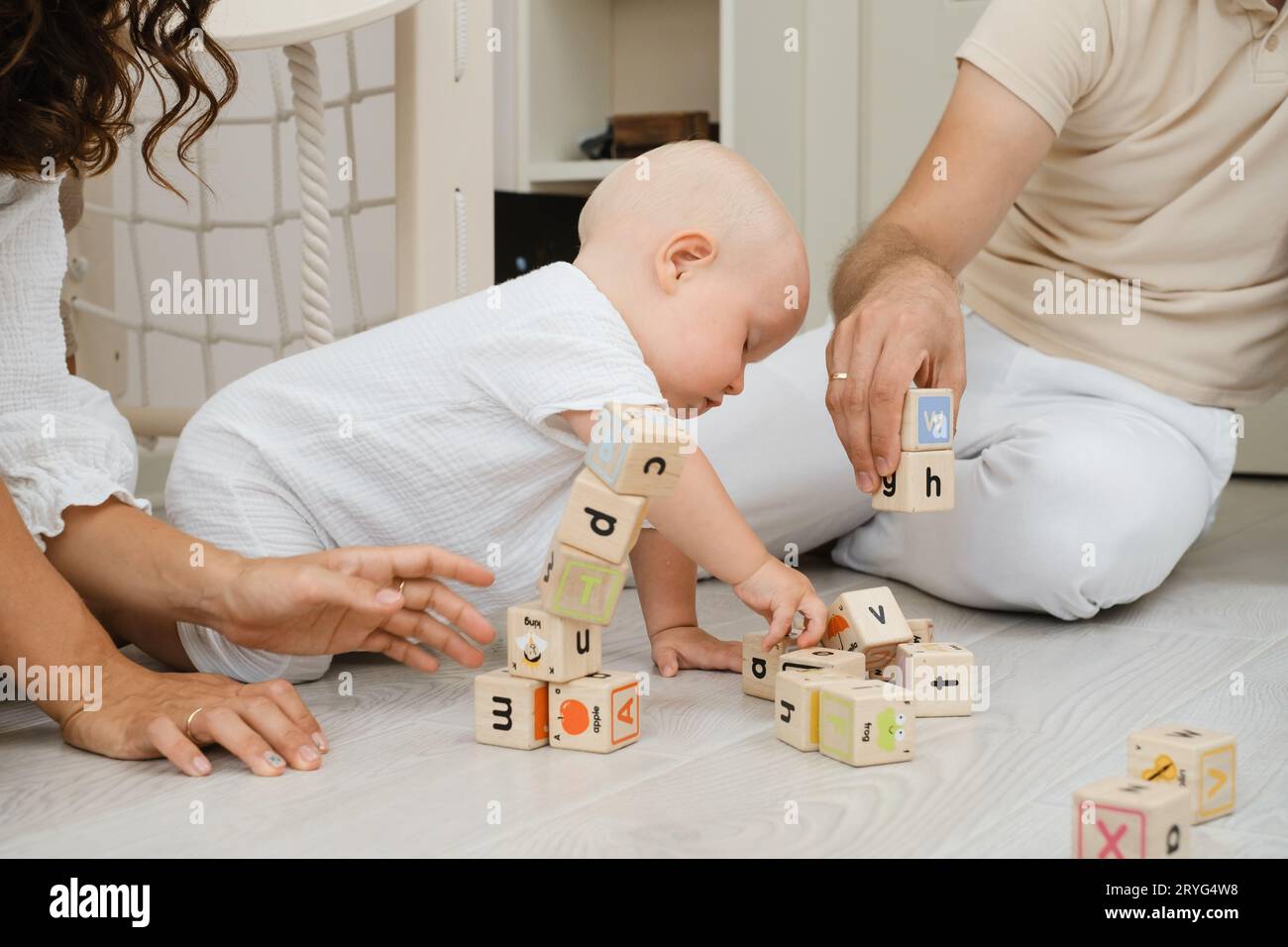 Child early development. Parents building from wooden cubes on the ...
