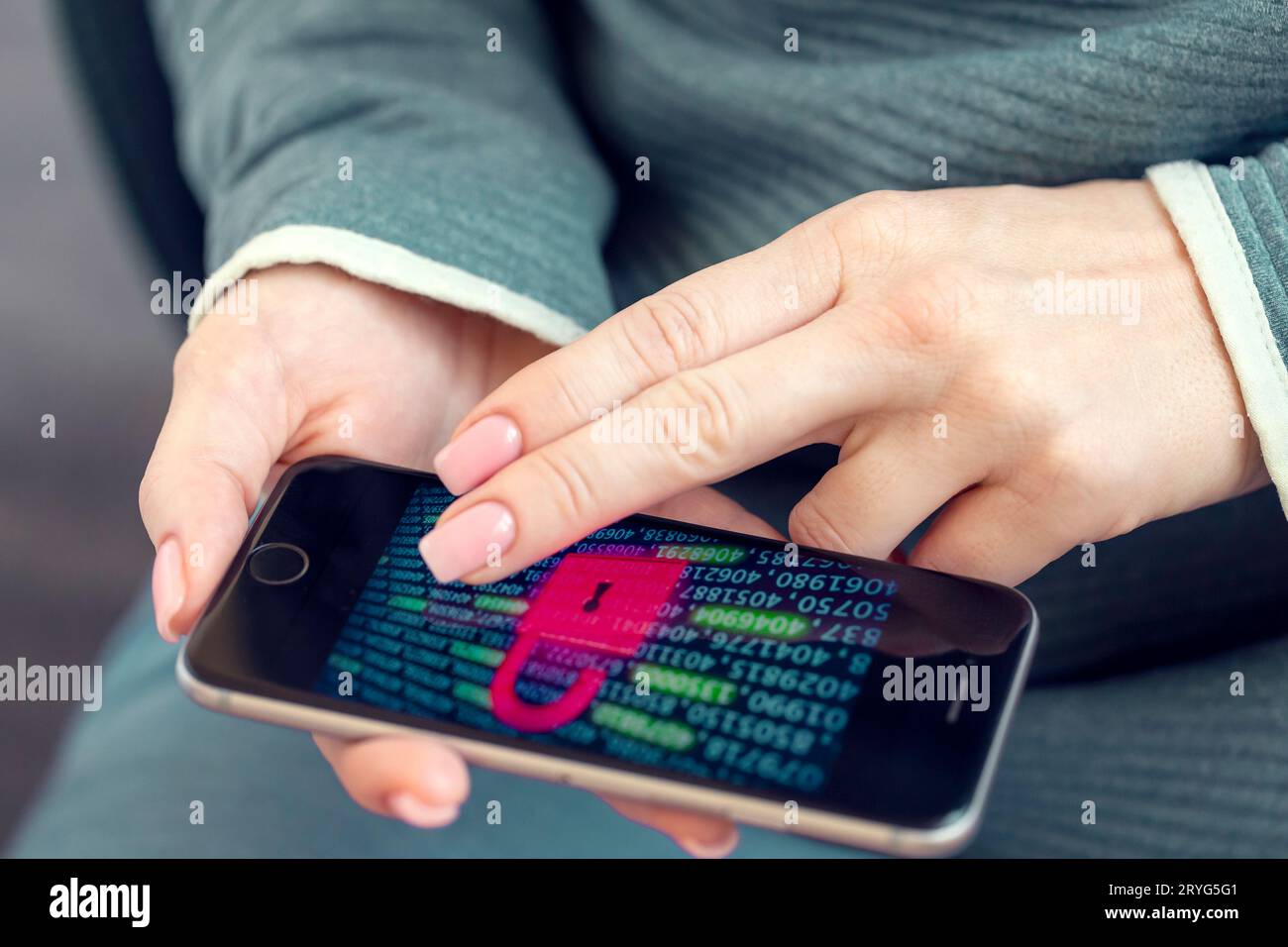 Mobile phone in female hands with screen showing compromised virus infected device. Cyber attack ...
