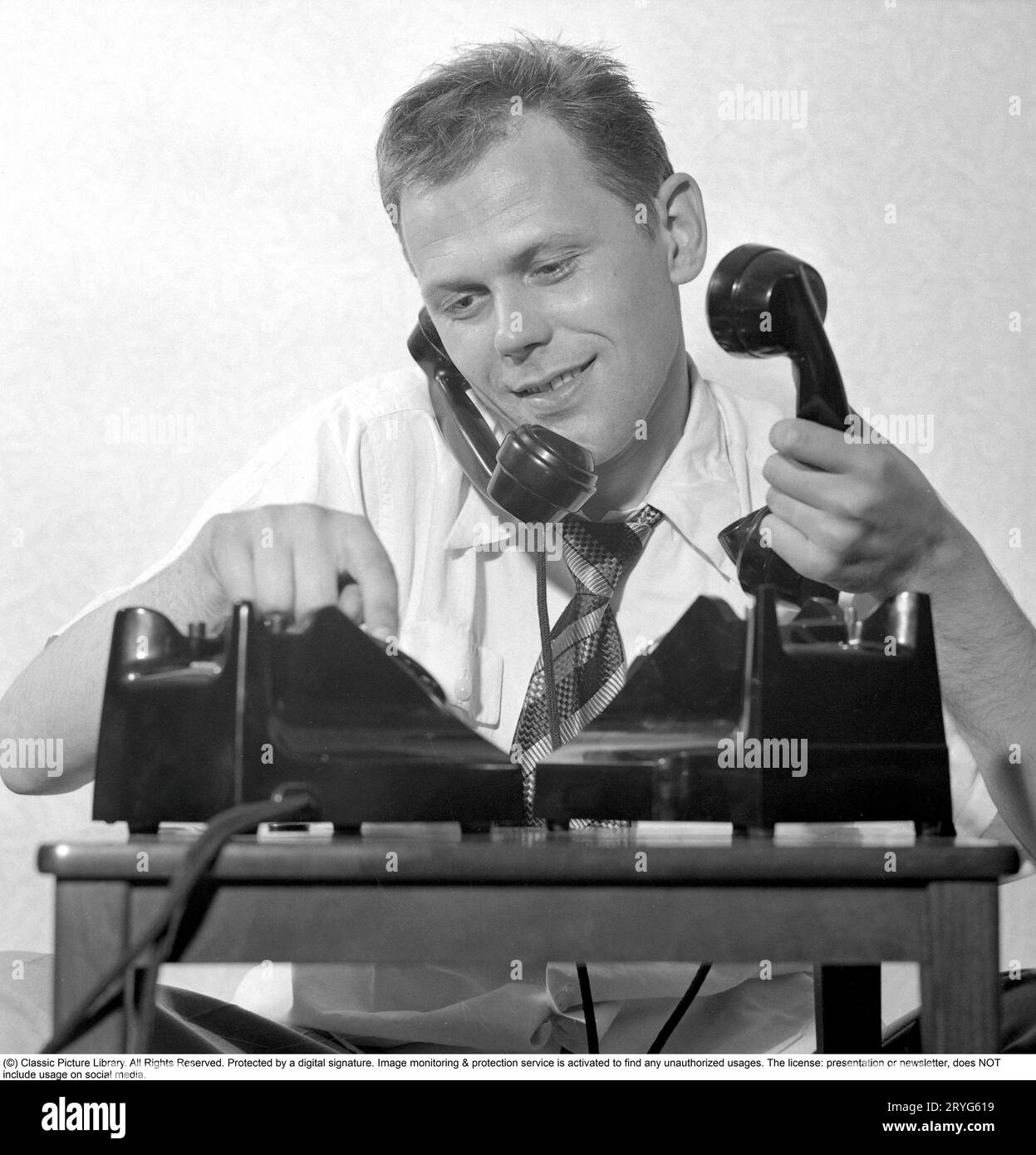 In the 1950s. Sixten Larsson with two telephones looking busy when ...