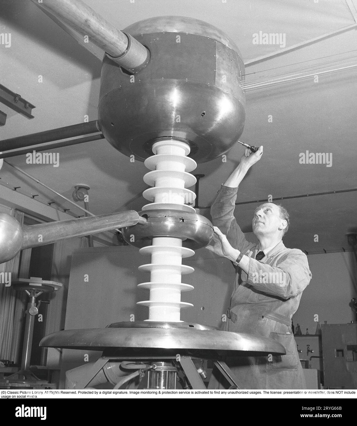 Man and machine in the 1940s. A man is seen in a room with a unusual ...