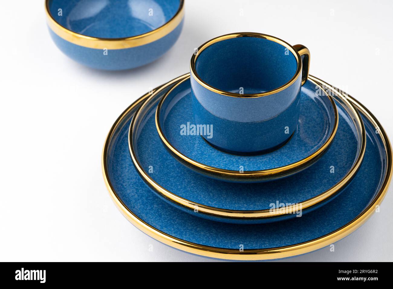 A set of blue ceramic plates and cup on a white background Stock Photo ...
