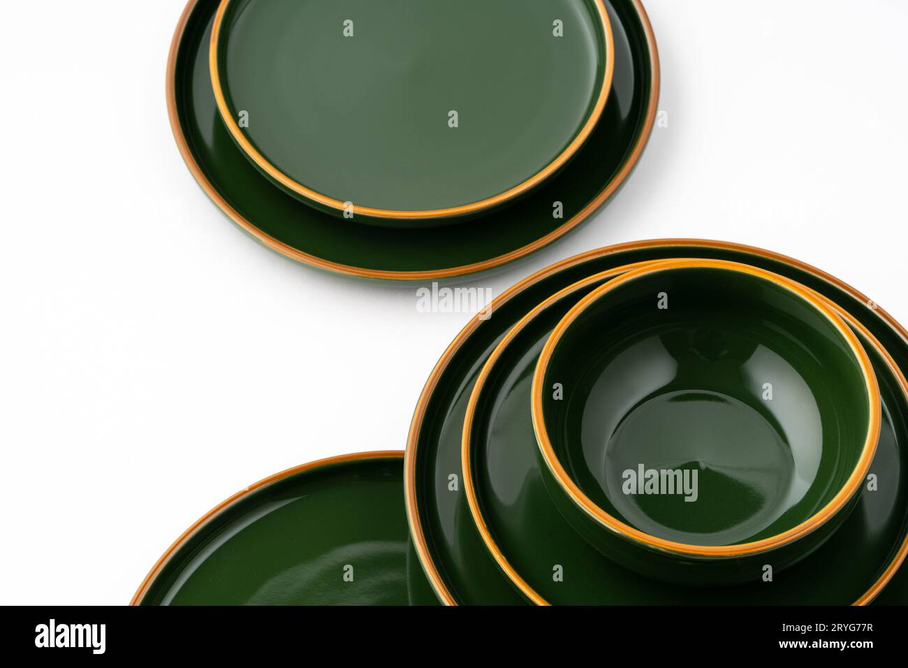 A set of green ceramic plates and bowl on a white background Stock ...
