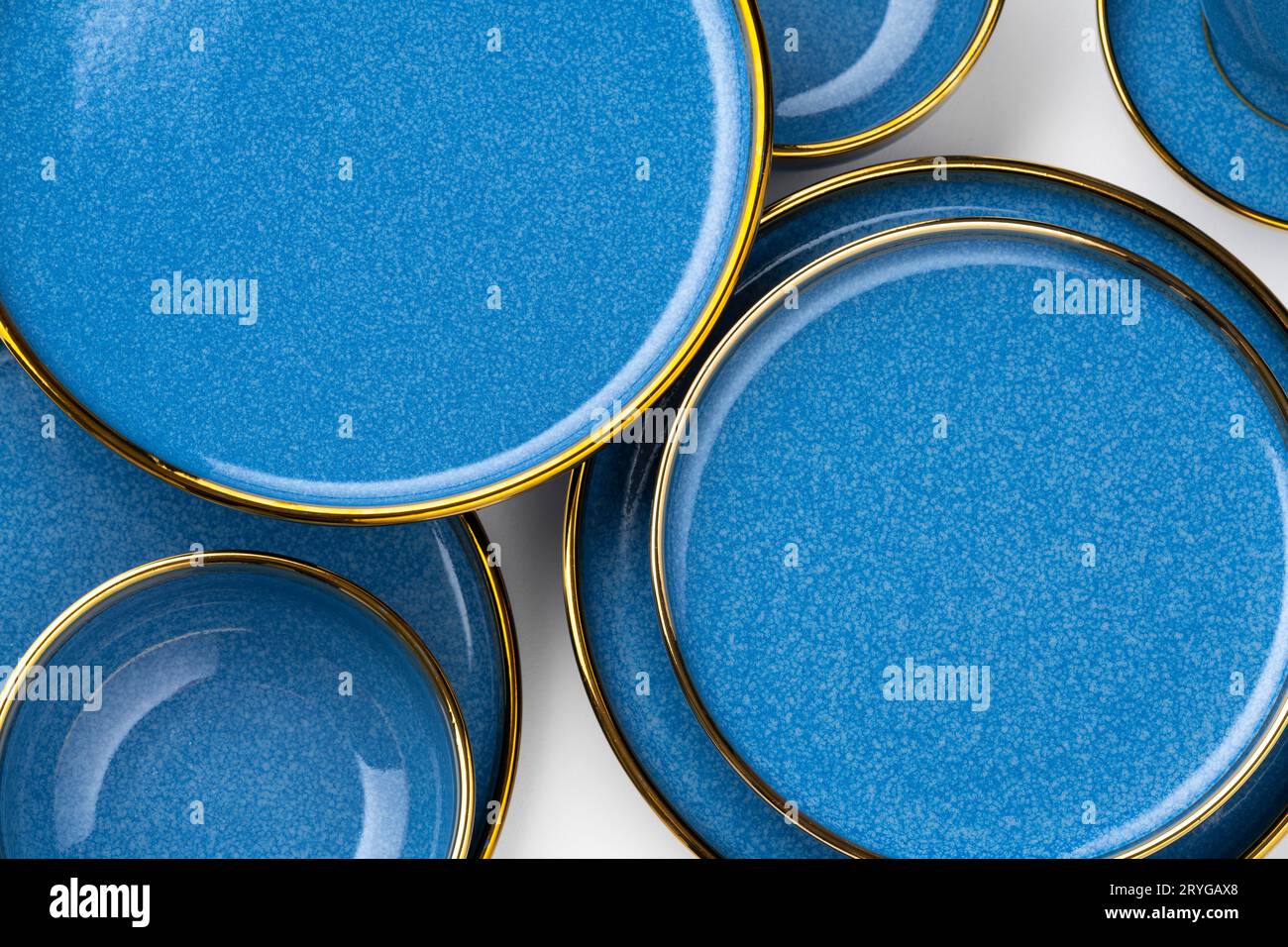 A set of blue ceramic plates on a white background. Top view Stock ...