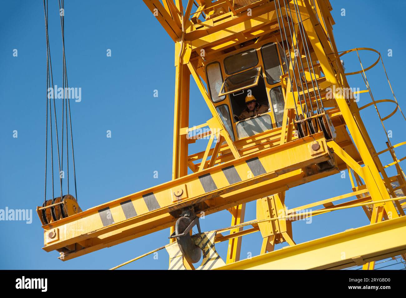 A worker in the cabin controls a construction crane Stock Photo - Alamy
