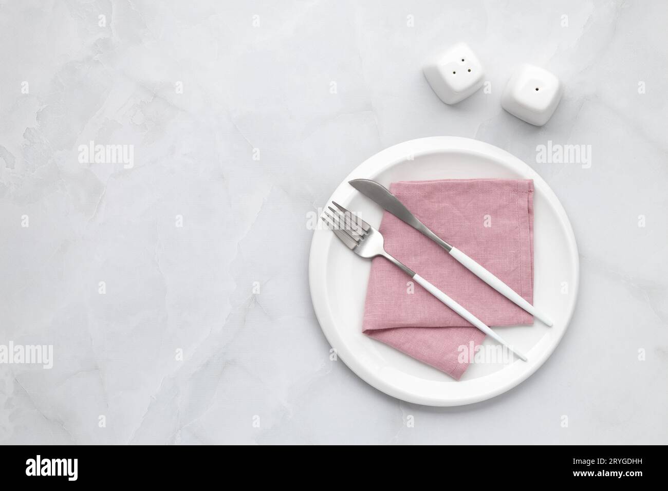 White plate with silver cutlery. Knife and fork on gray marble ...