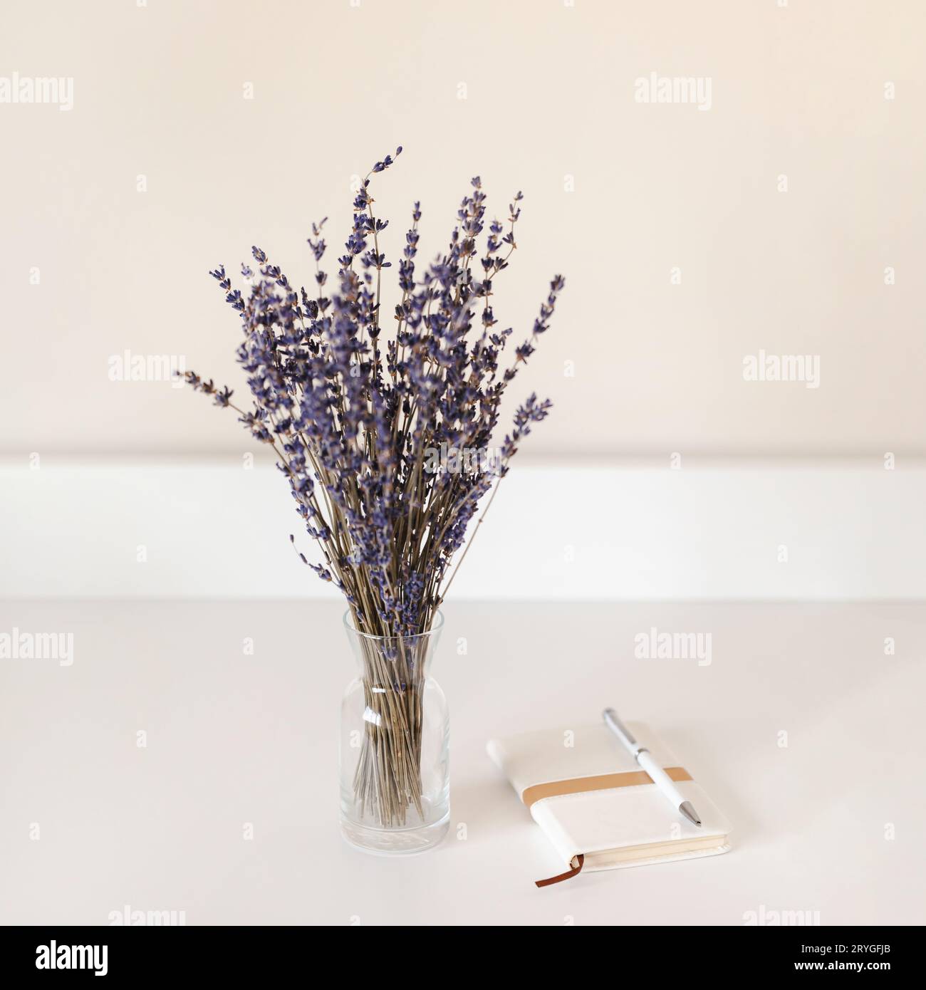 Lavender flowers in a vase on a table with notebook and pen, spring ...