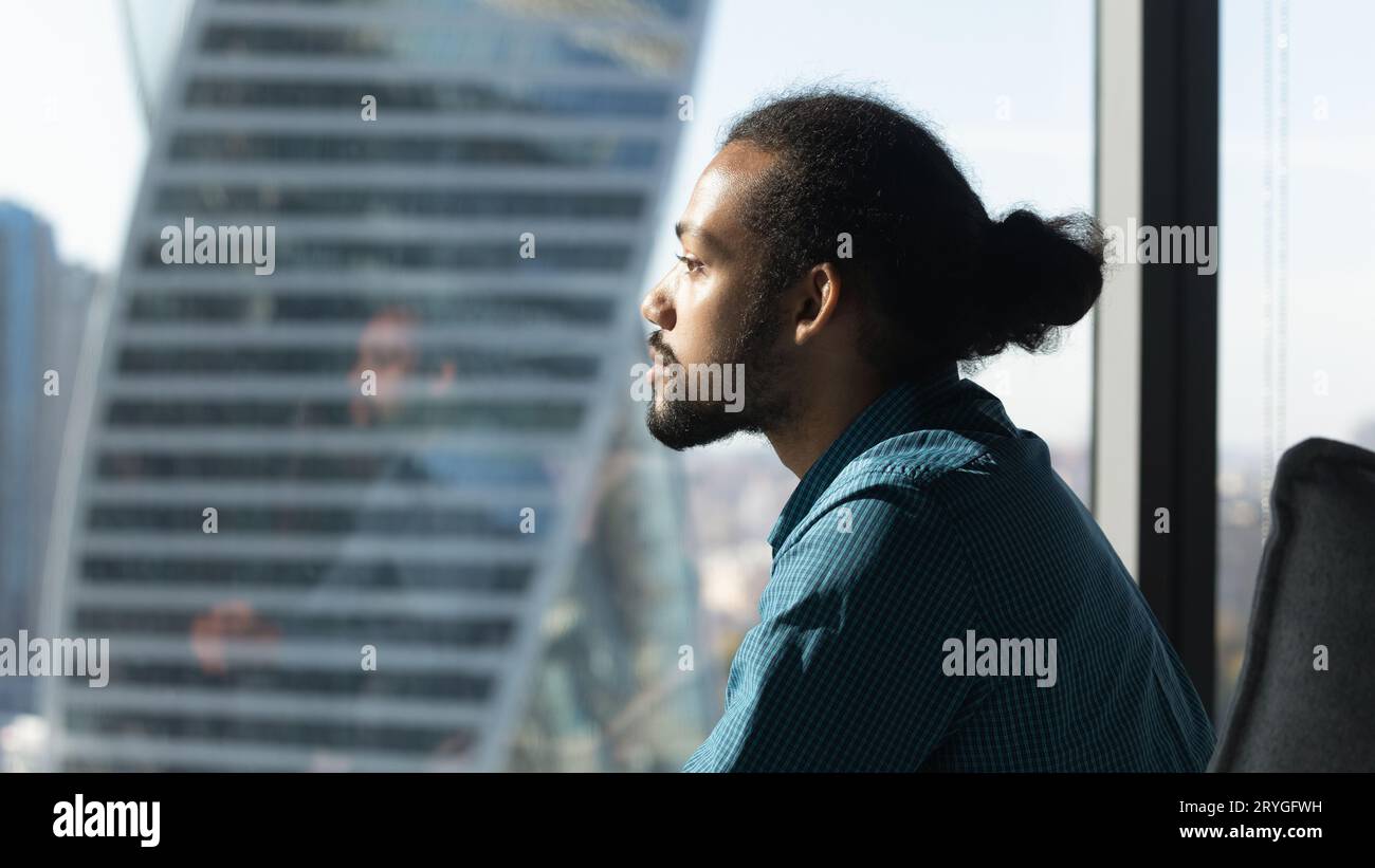 Side view dreamy African American businessman looking out window Stock ...