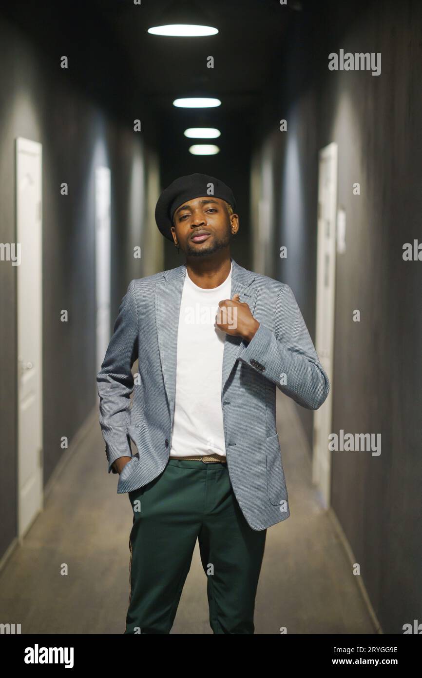 A young arrogant African looks down on holding his hand to the lapel of ...