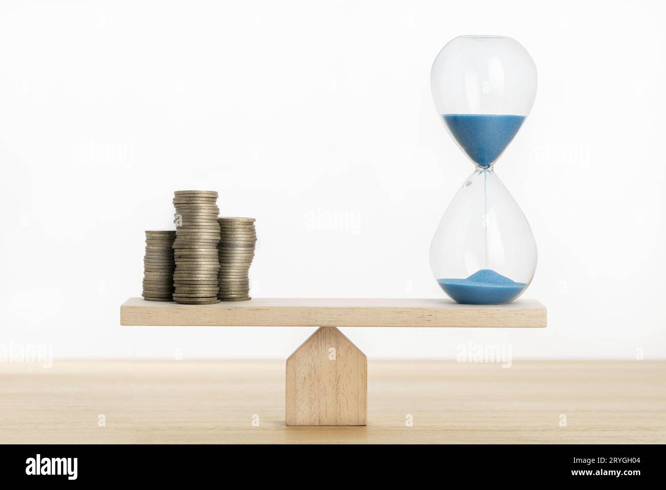 Time and money balance concept. Sand clock and stacked coins on Seesaw ...