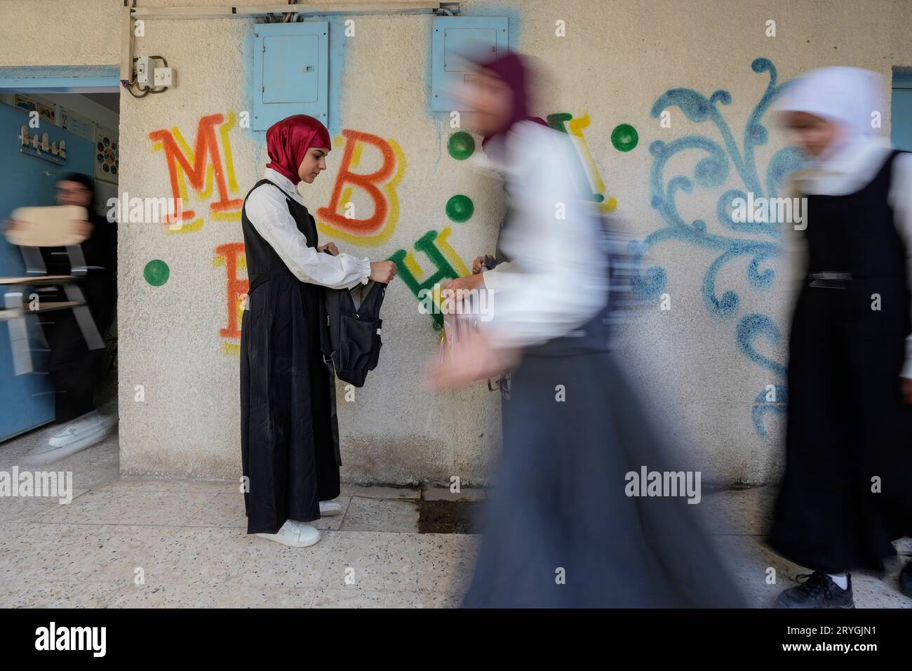 Students prepare to enter a classroom in their new uniforms on the ...