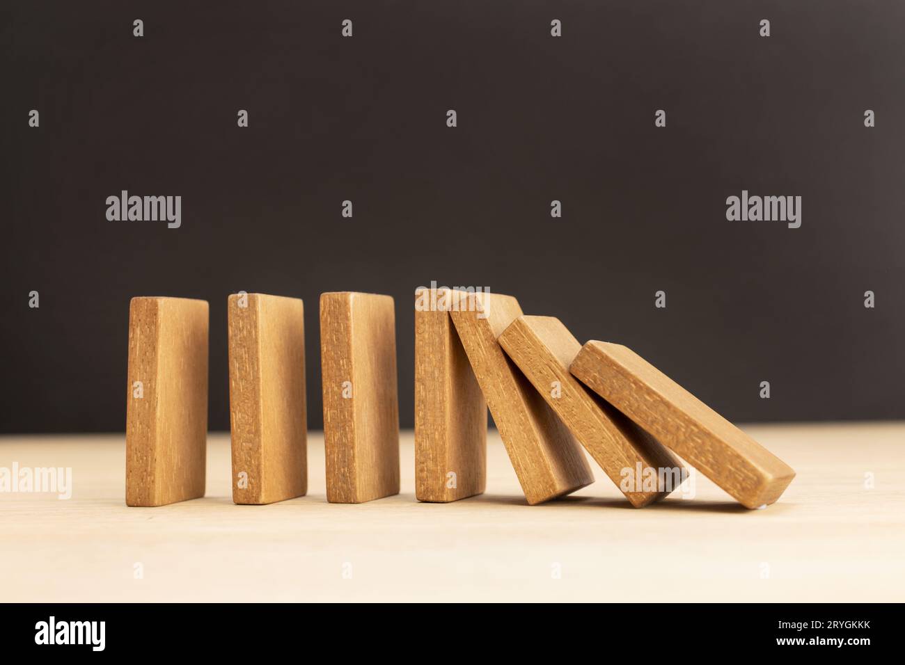Falling wooden Dominoes effect Stock Photo - Alamy