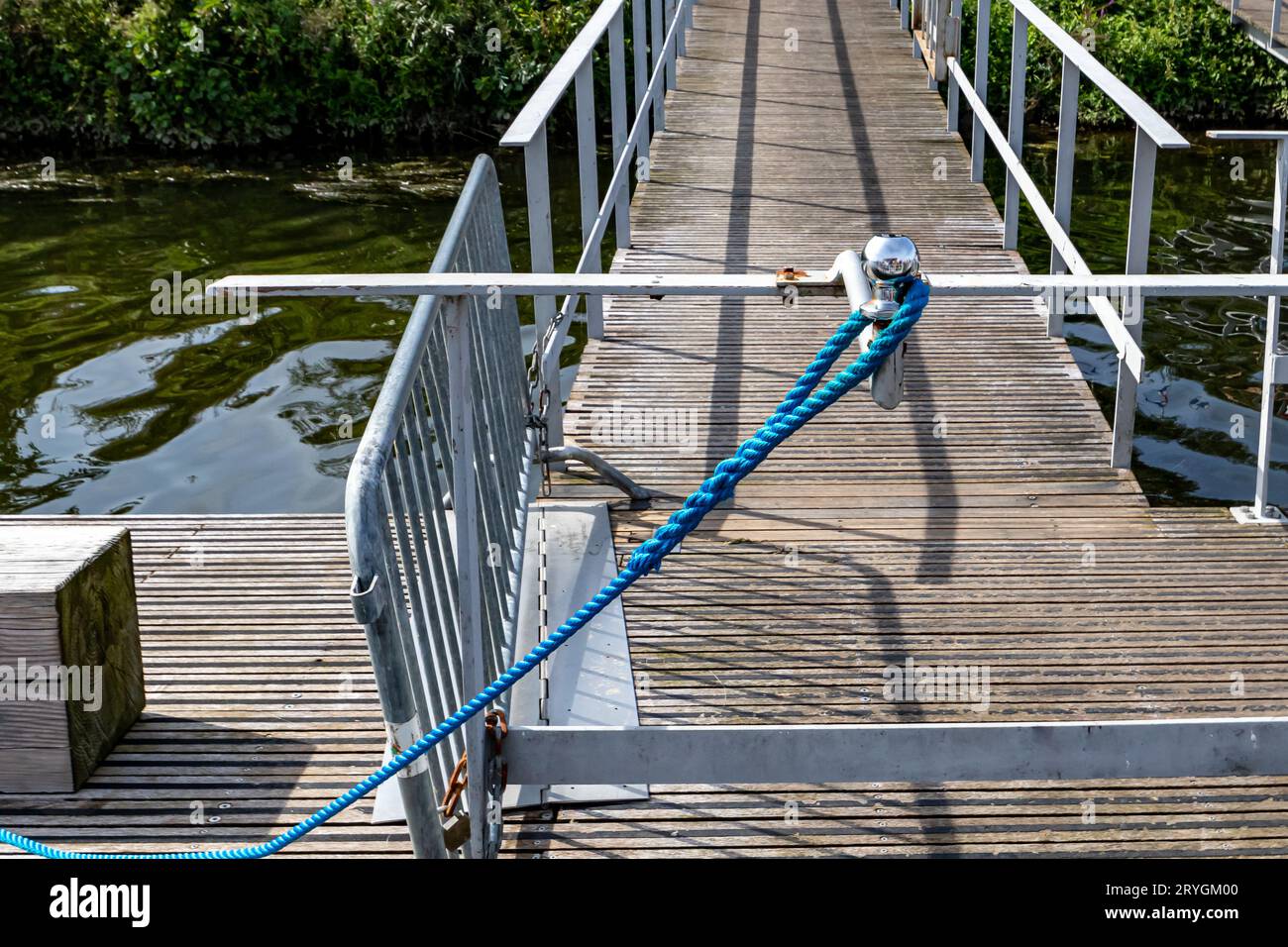 Blue rope tied to a berth or mooring on a wooden platform at ferry dock ...