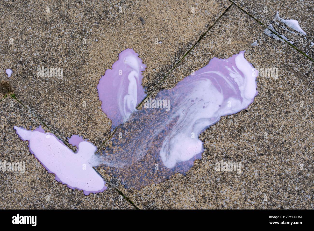 A spilled milkshake on the pavement in the town centre. Concept of ...
