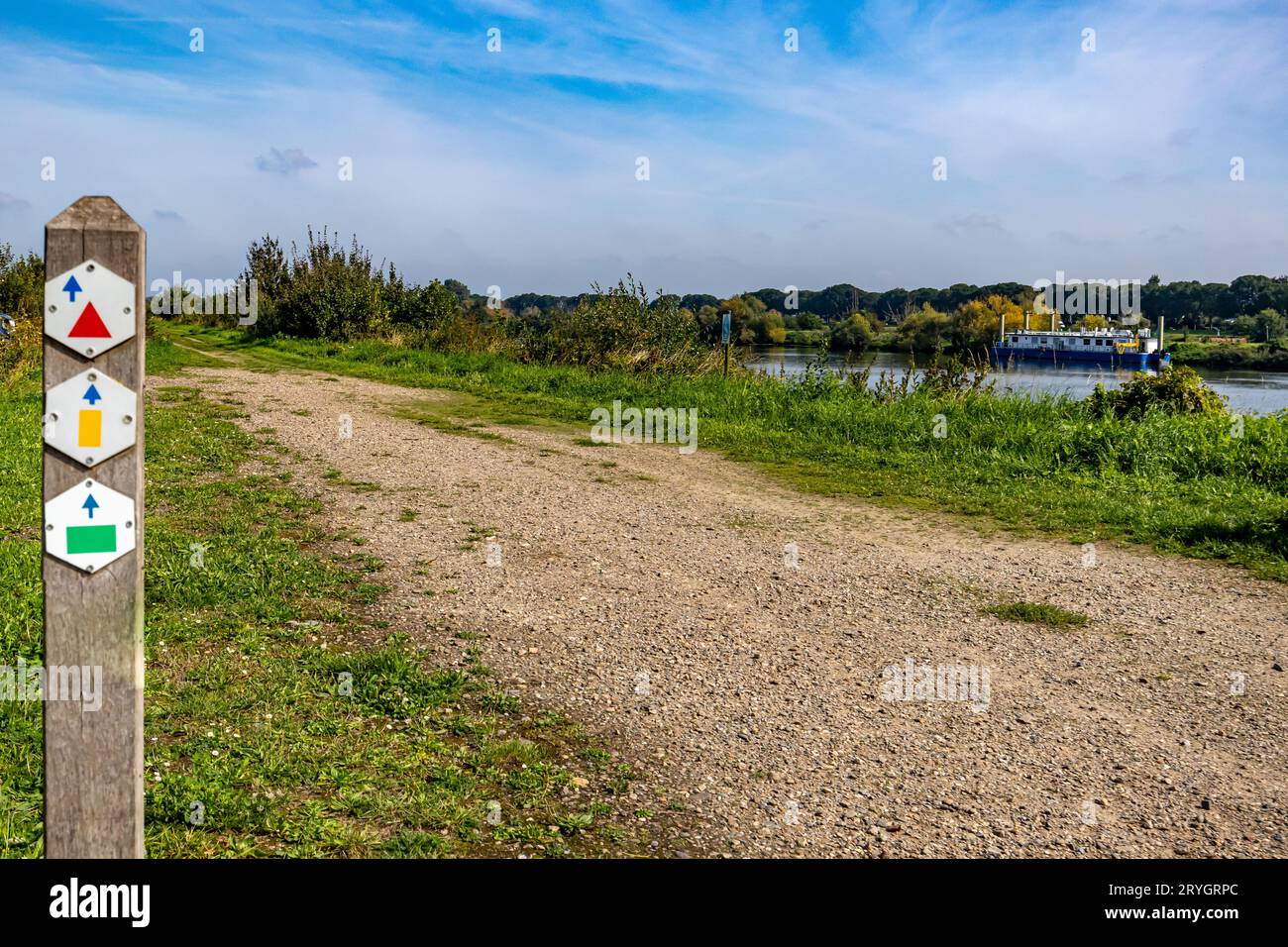 Wooden post with sign of different hiking route next to path between ...