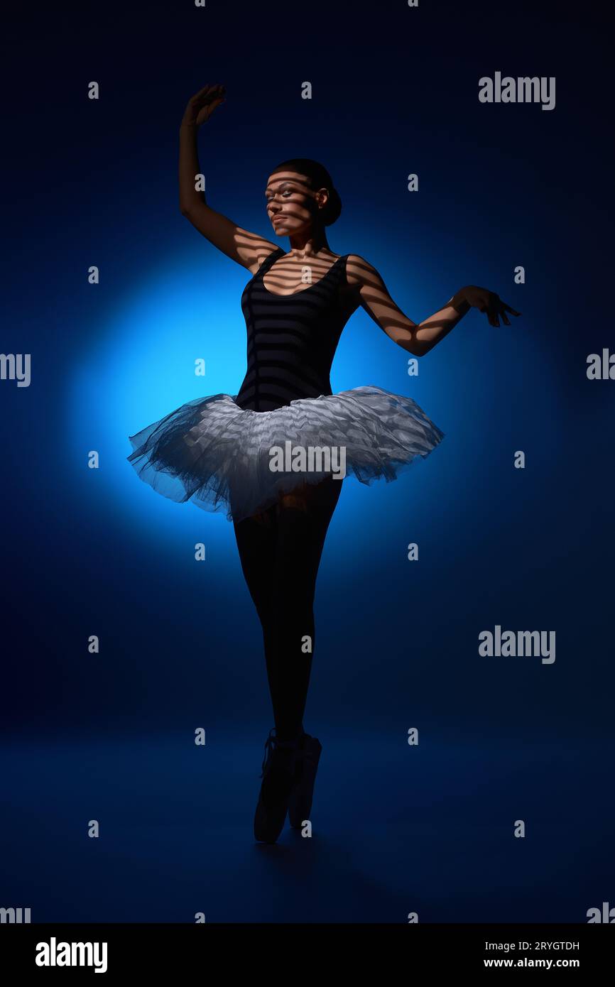 Feminine young ballerina dancing in blue studio Stock Photo - Alamy