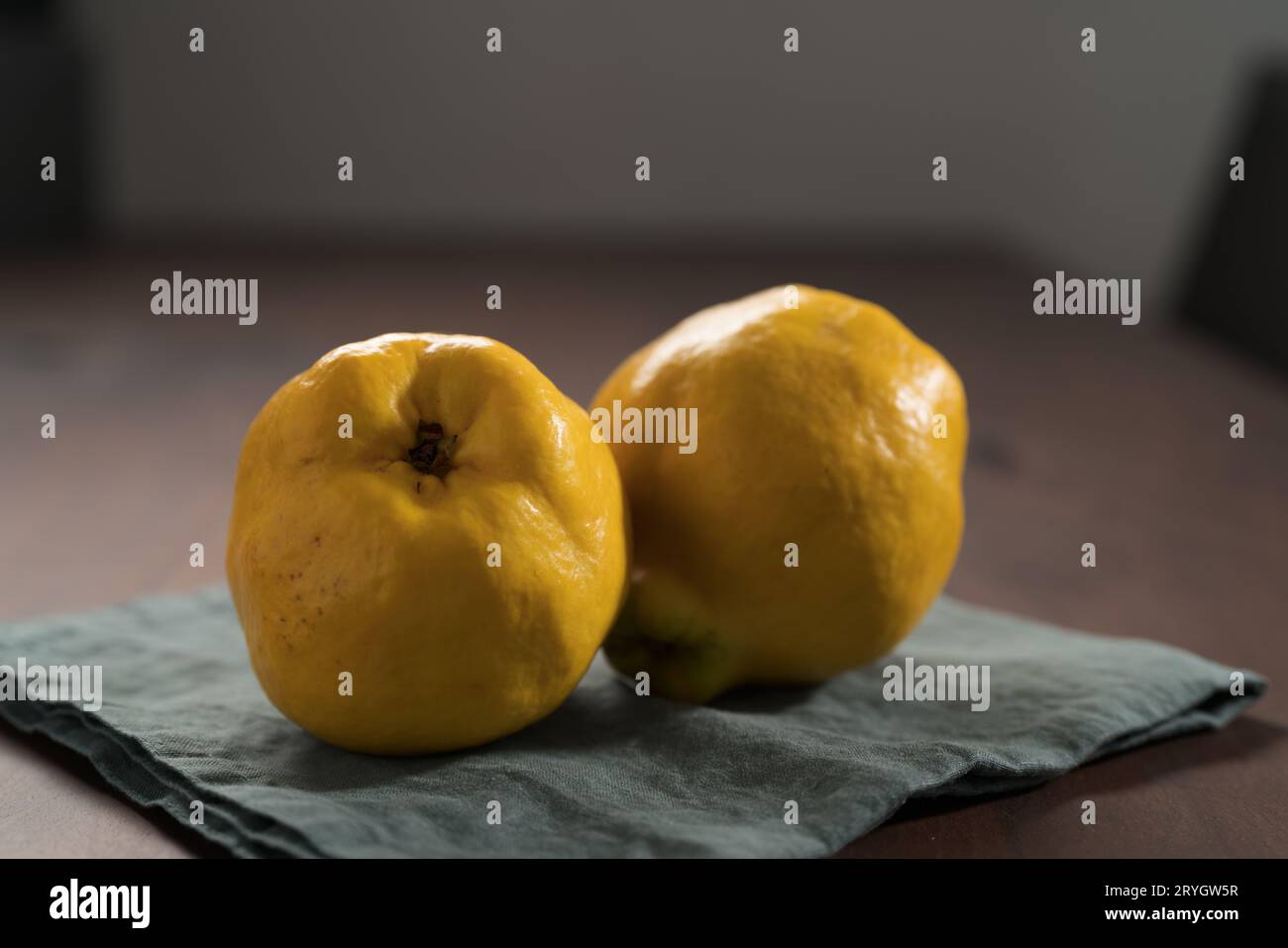 Two ripe quince fruit on wood table, shallow focus Stock Photo - Alamy