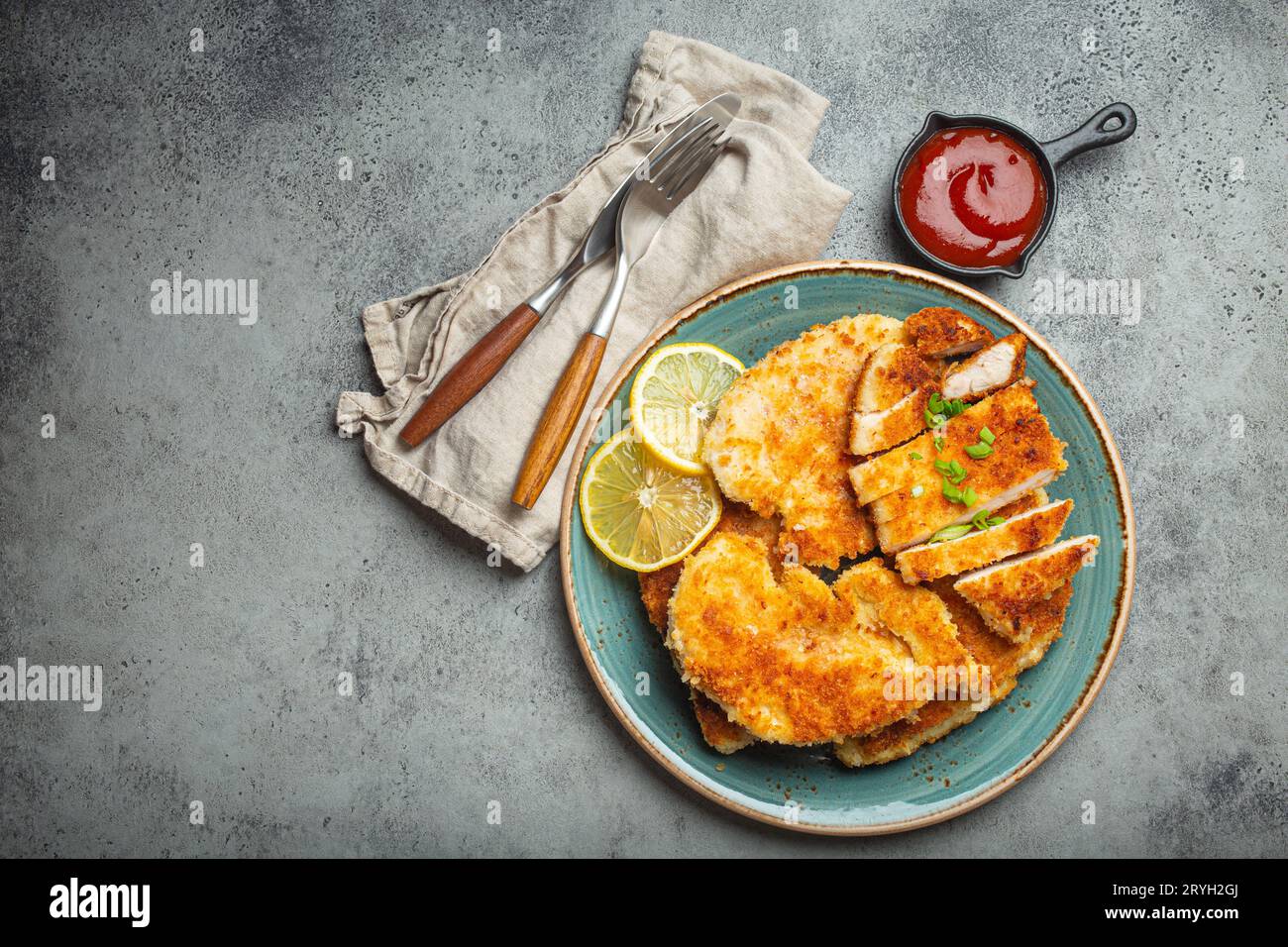 Crispy panko breaded fried chicken fillet with green salad and lemon ...