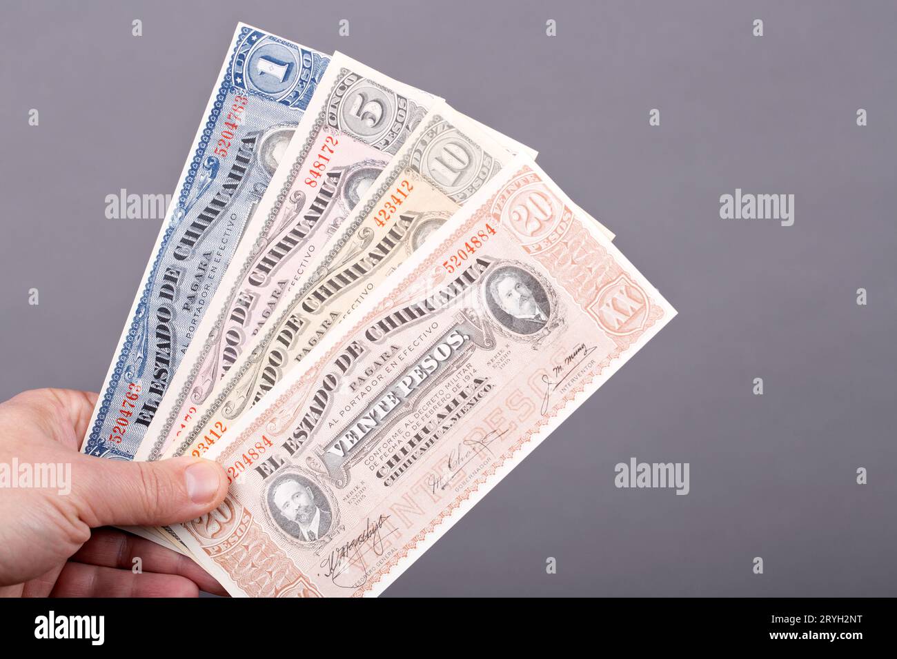 Old Mexican money in the hand on a gray background Stock Photo - Alamy