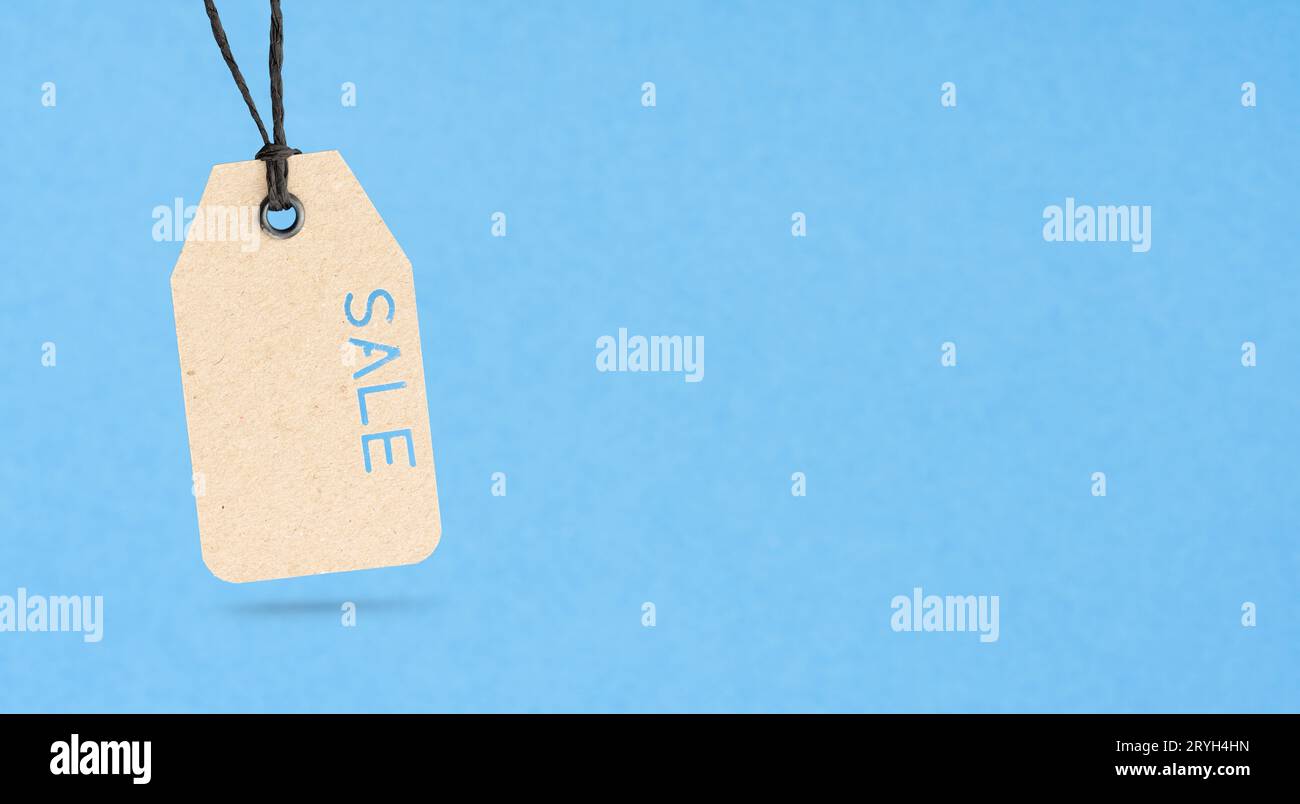 Sale Price tag with text cut out on cardboard isolated on blue ...