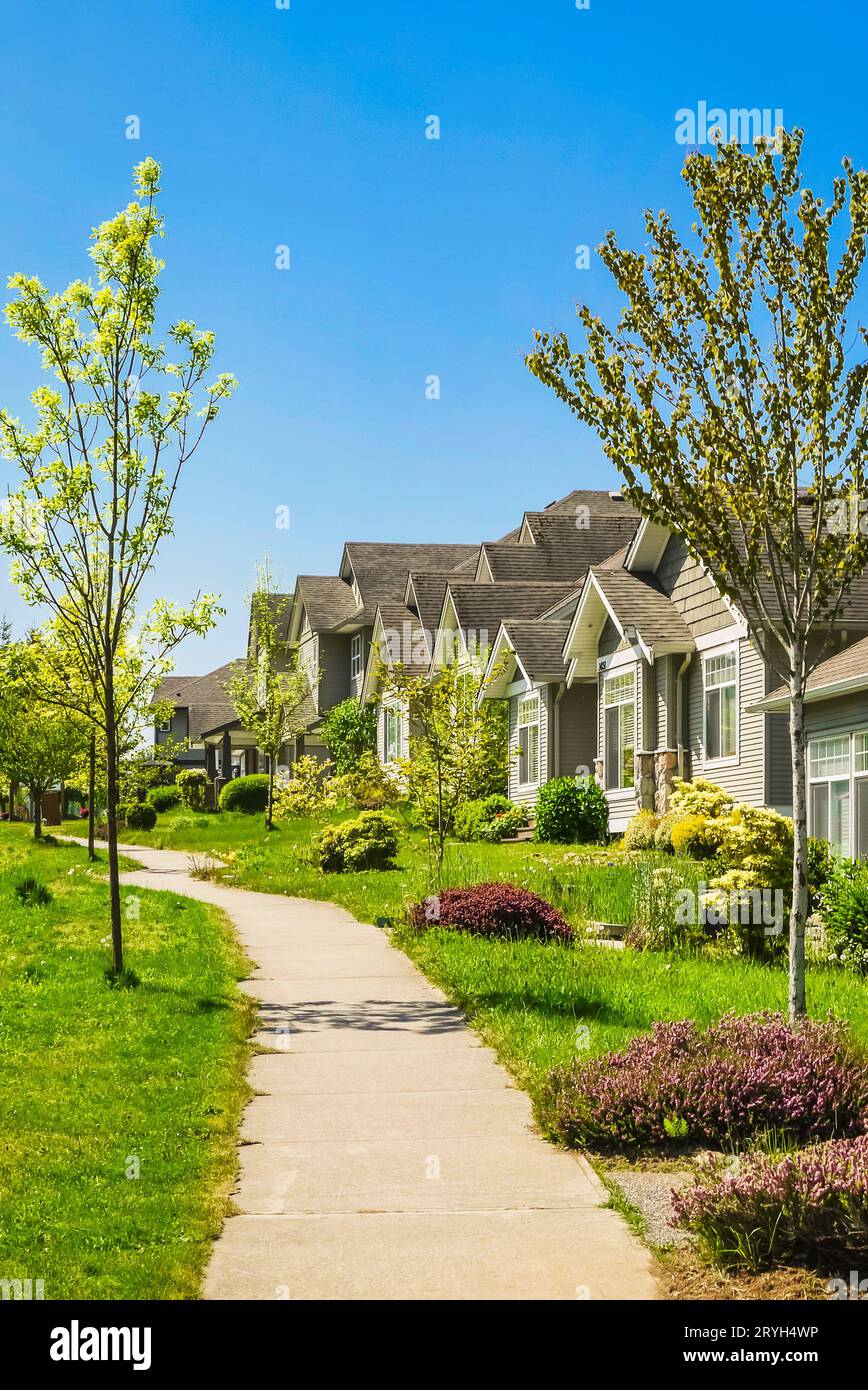 Concrete pathway along the row of residential houses on a sunny day ...