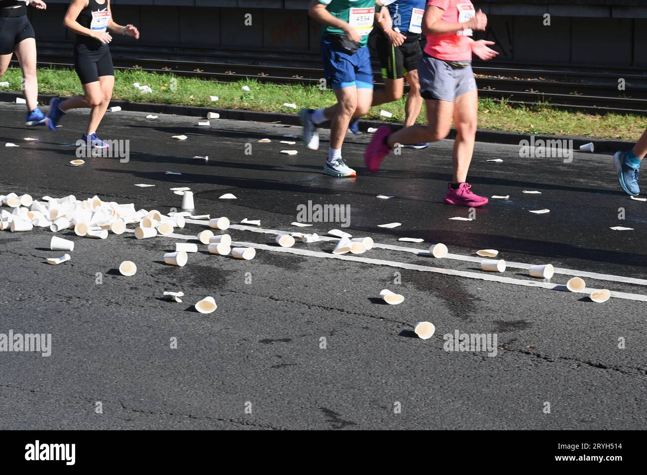 Läufer auf der Strecke des Generali Köln Marathon und leere Becher liegen auf der Strasse ...