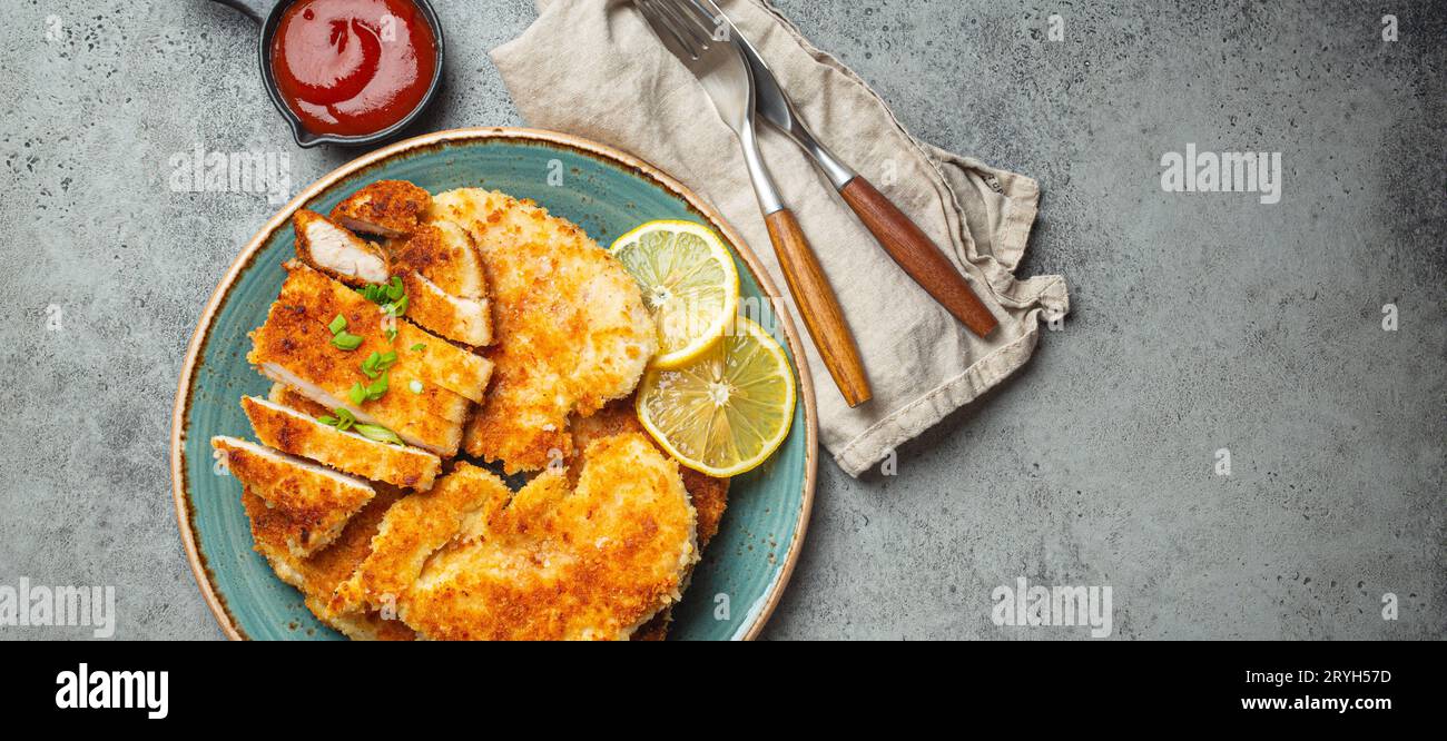 Crispy panko breaded fried chicken fillet with green salad and lemon ...