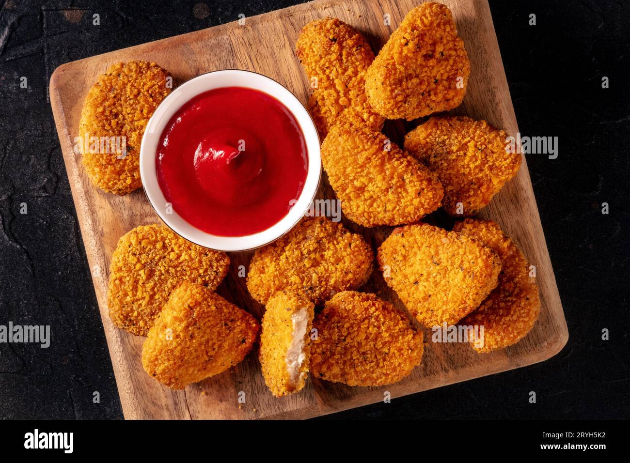 Chicken nuggets with bbq sauce on a wooden board, top shot. A crispy ...