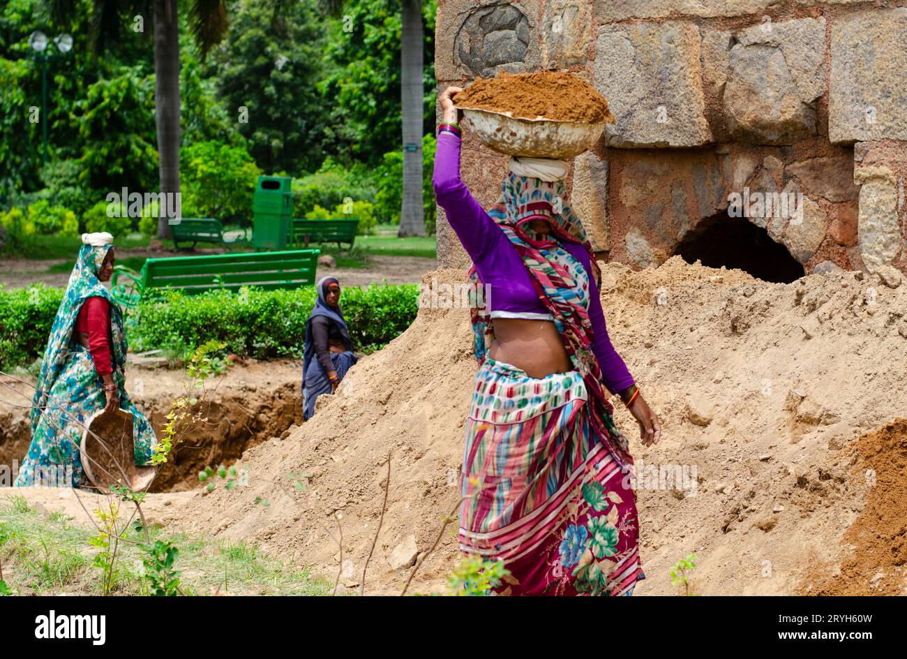 Indian women working on construction industry outdoors carrying sand on ...