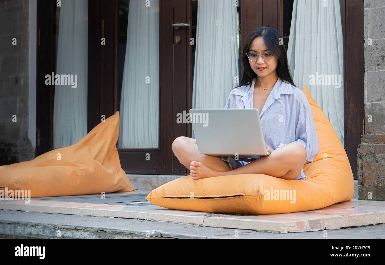 Woman using laptop for working around swimming pool Stock Photo - Alamy
