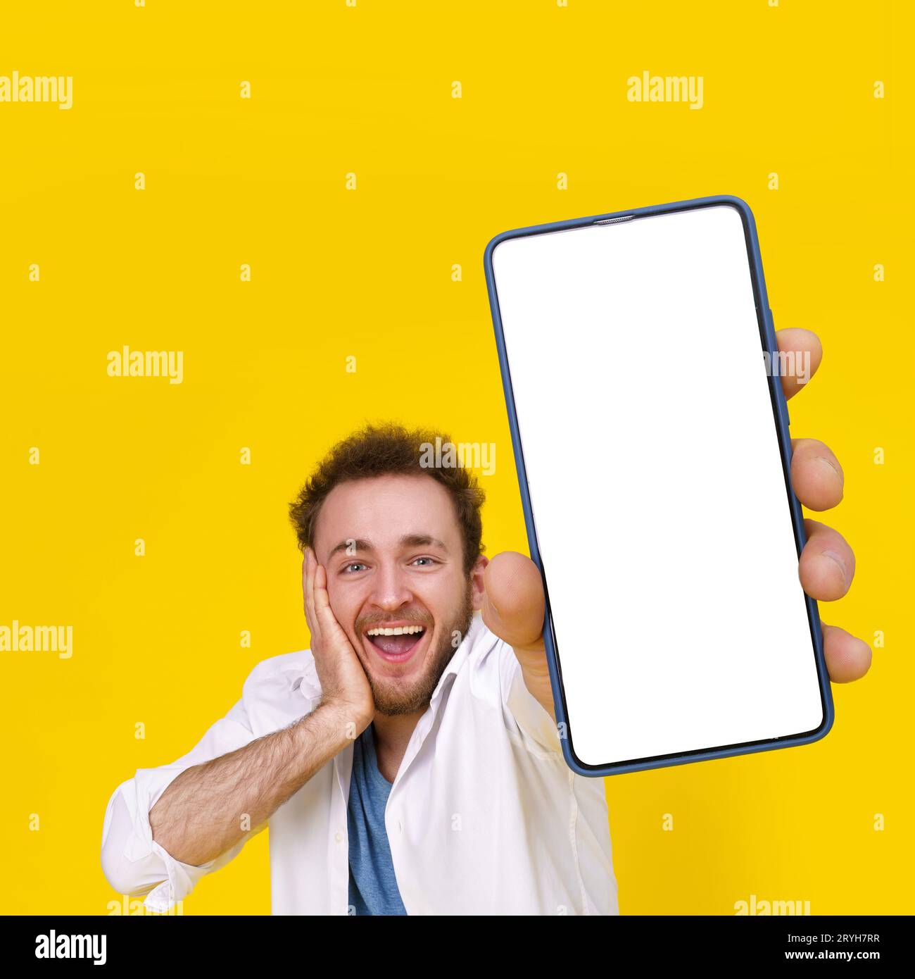 Exited man show phone isolated on yellow background. Advertising ...