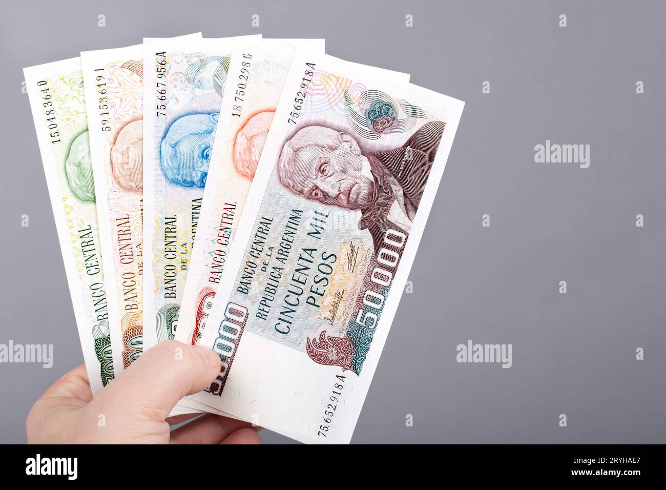Old Argentine peso in the hand on a gray background Stock Photo - Alamy