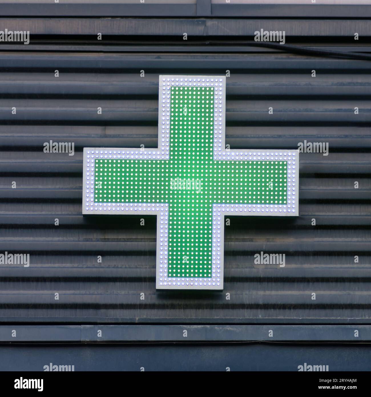 Green cross pharmacy signs on the wall of a city house Stock Photo - Alamy