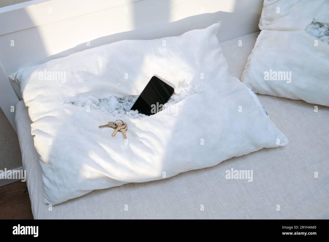 The phone and house keys are hidden in a secret pillow. Torn pillow on ...