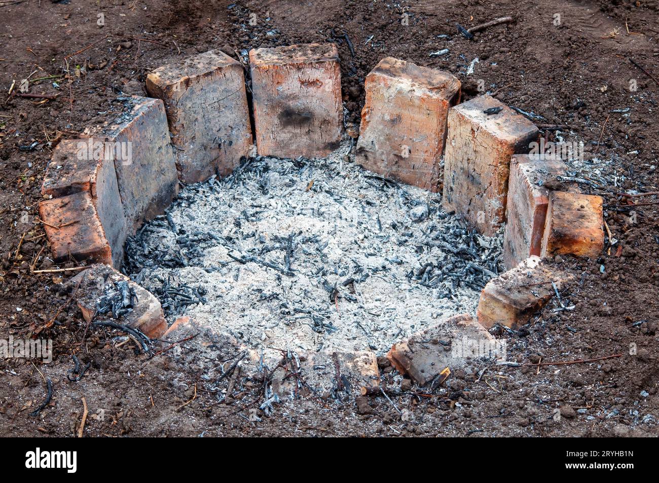 A round hearth sunken into the ground is reinforced with bricks, ash ...