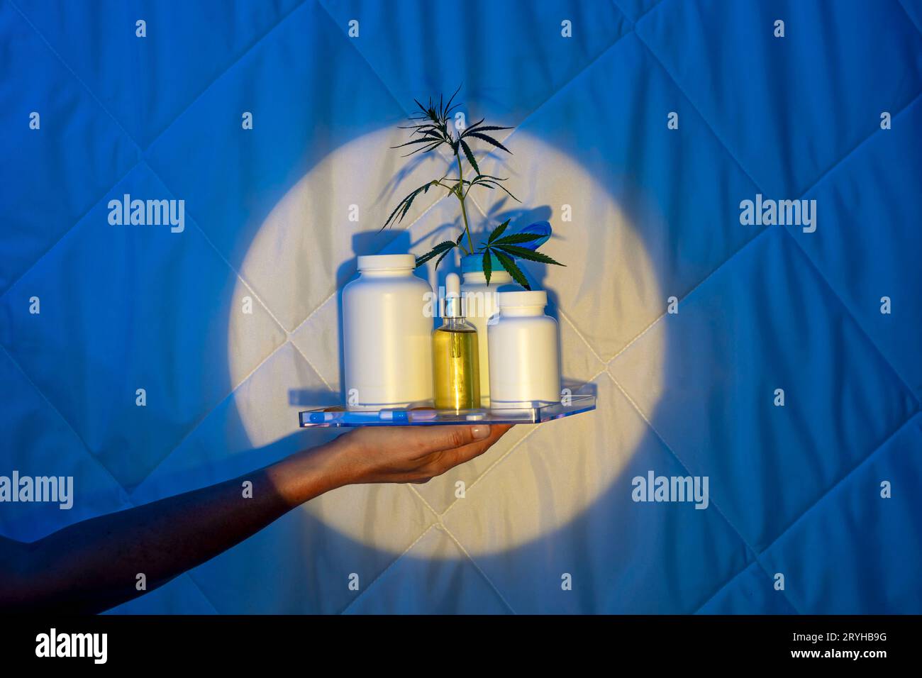 Sleeping capsules with a branch of cannabis, hand in moonlight on a ...