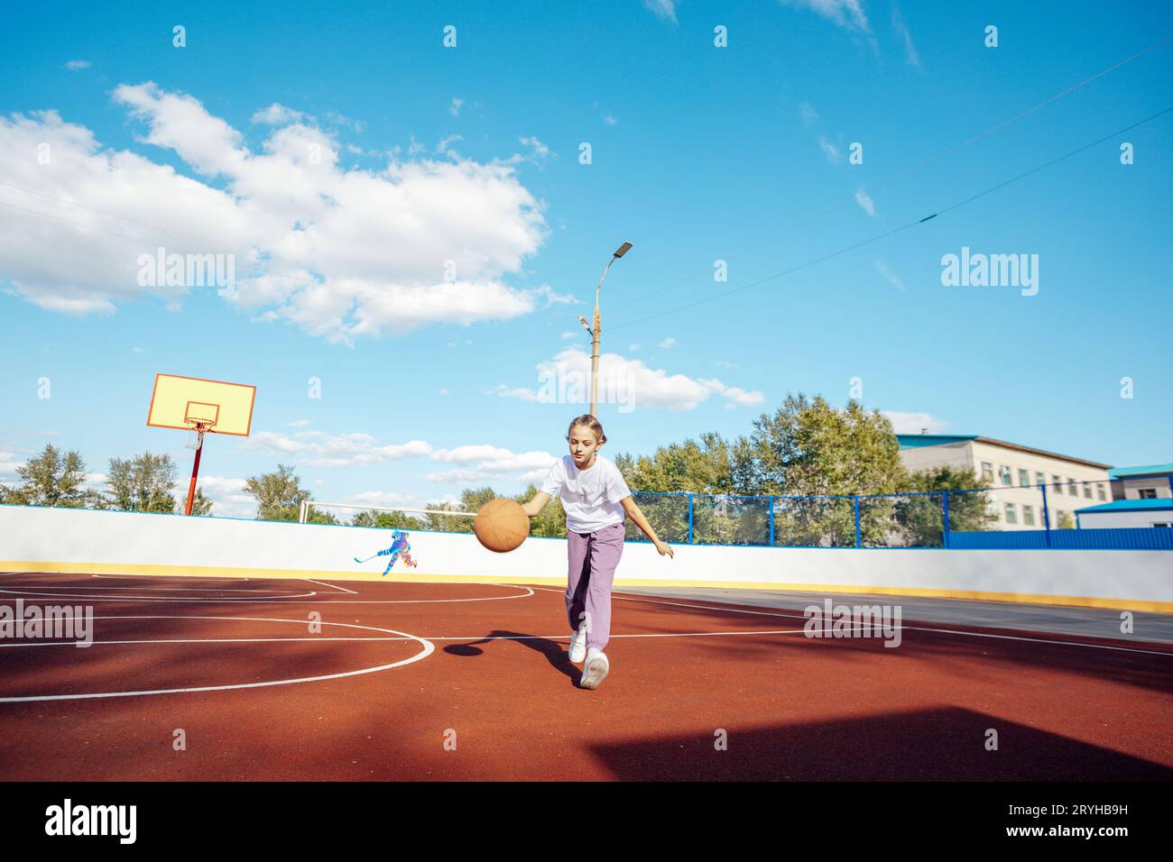 Girl's Resilience Radiates in Outdoor Basketball Match Stock Photo - Alamy