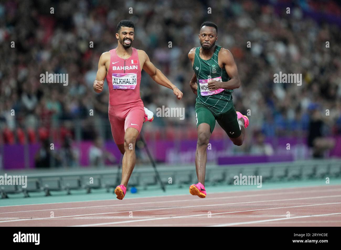 Saudi Arabia's Abdullah Abkar Mohammed, right, crosses the finish line ...