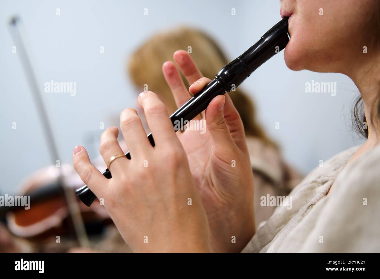 The musician hand, holding the instrument, is captured in a close-up ...
