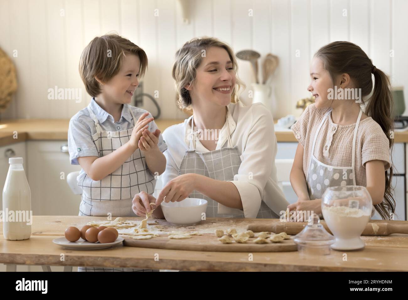 Caring mom cooking together with daughter and son Stock Photo - Alamy
