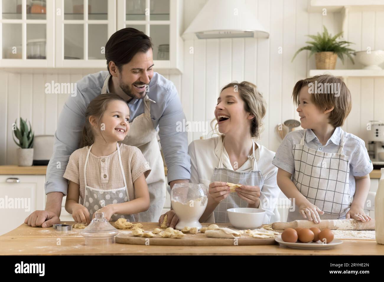 Laughing parents cooking together with kids in kitchen Stock Photo - Alamy