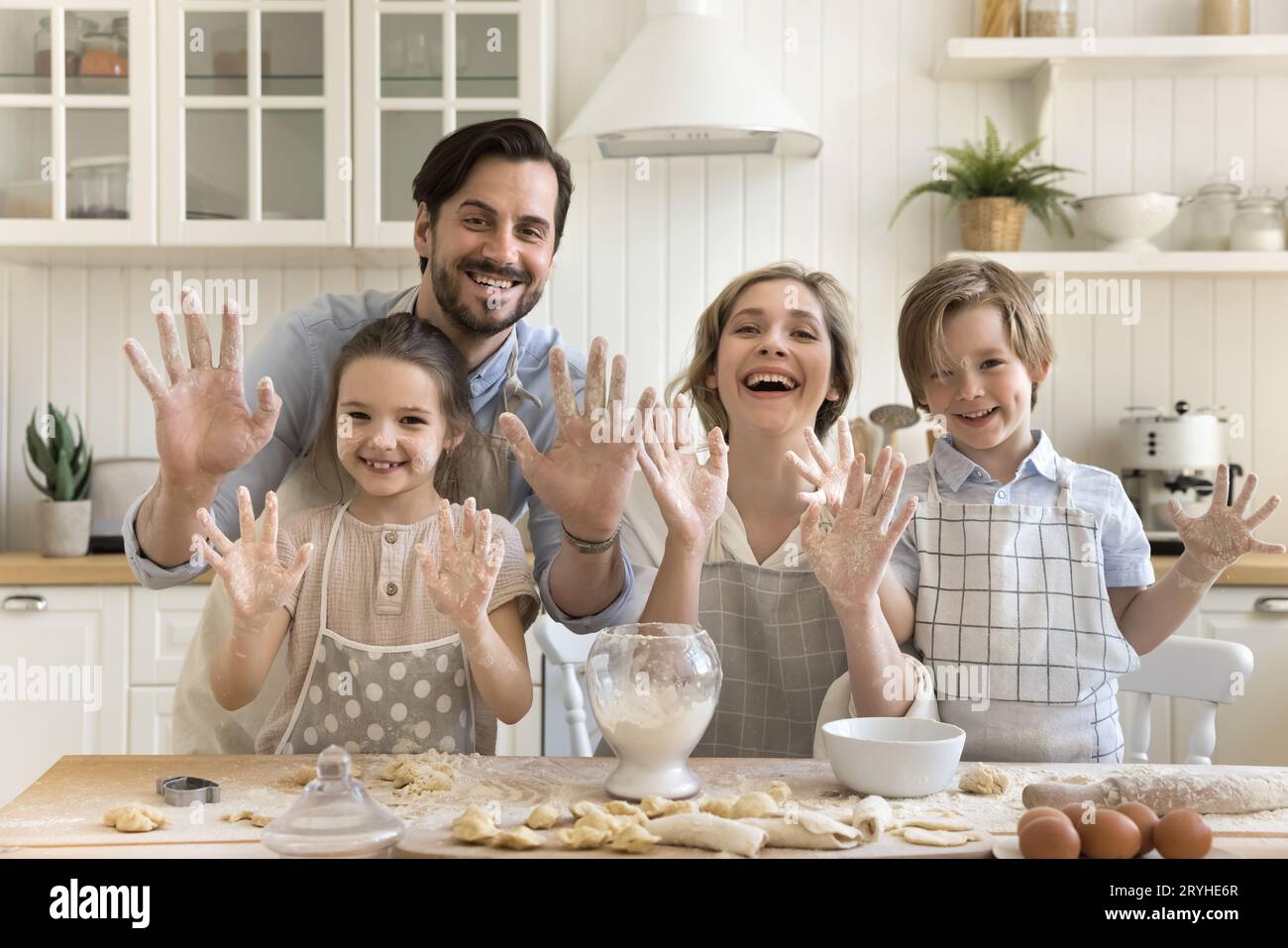 Playful parents and kids have fun while cooking together Stock Photo ...