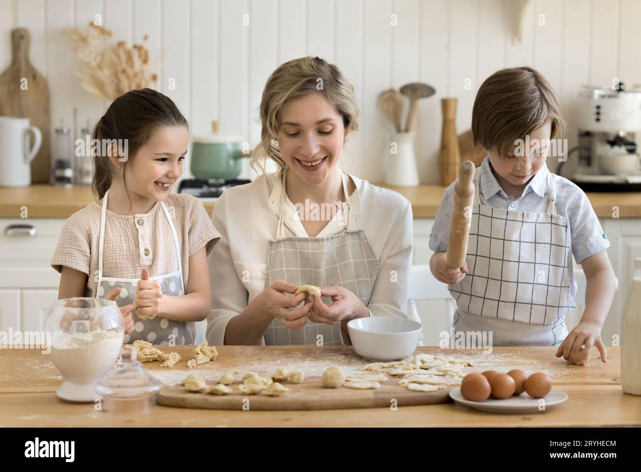 Caring mom teach to cute kids cooking in kitchen Stock Photo - Alamy