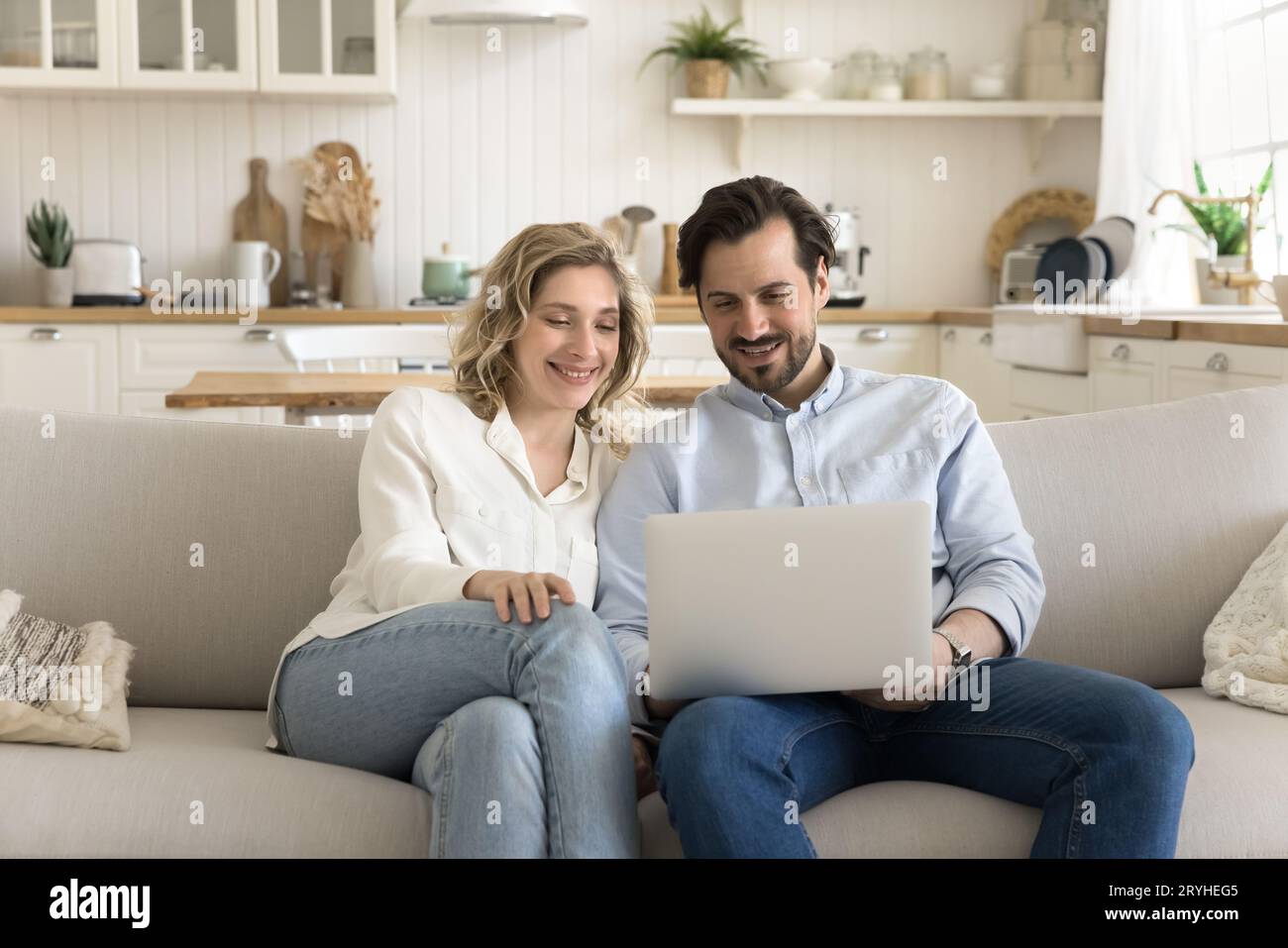 Millennial attractive couple watching movie on computer at home Stock ...