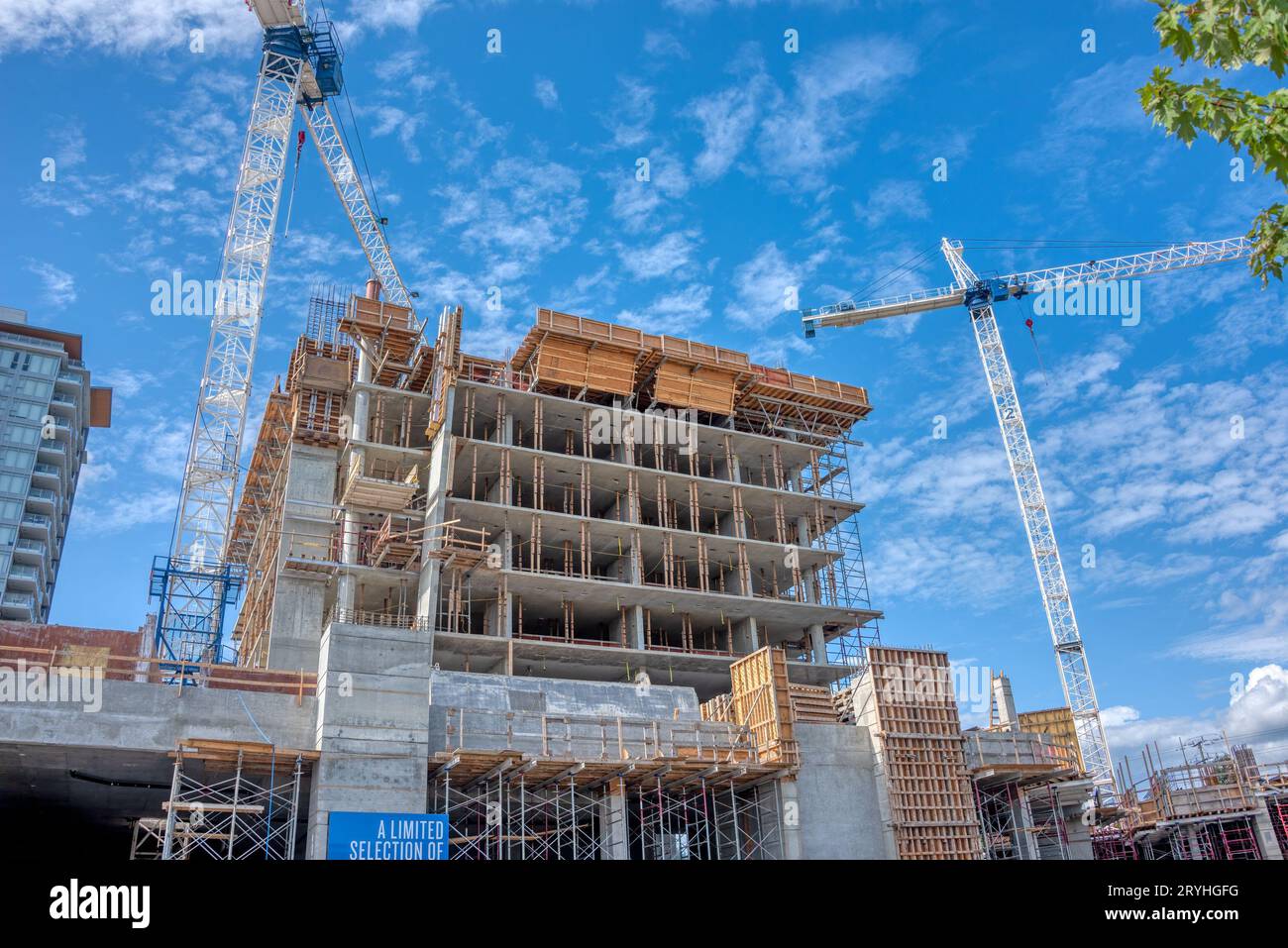 Concrete high rise residential building under constraction on blue sky ...