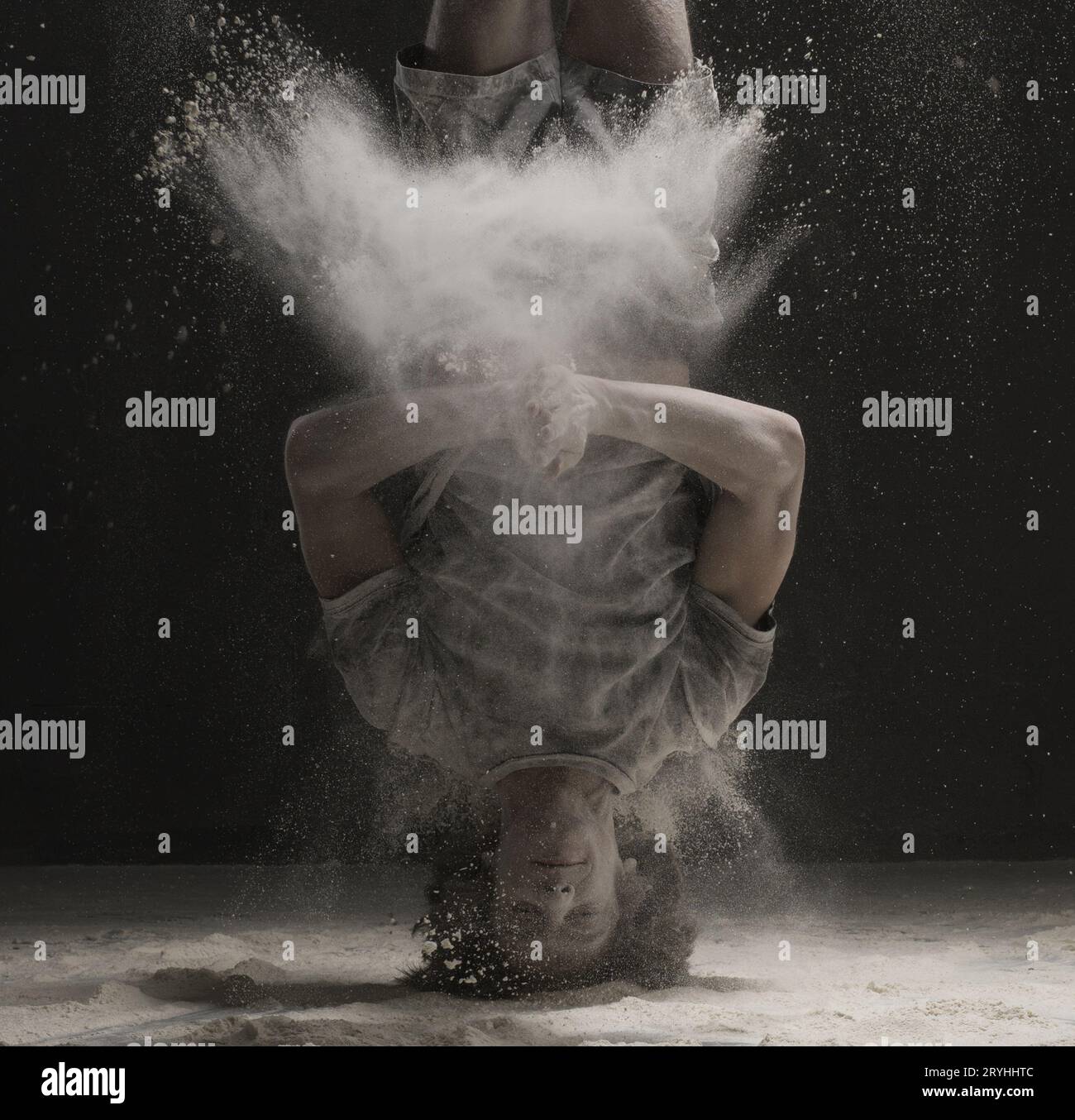 Young dancer doing a headstand in dust cloud view Stock Photo - Alamy