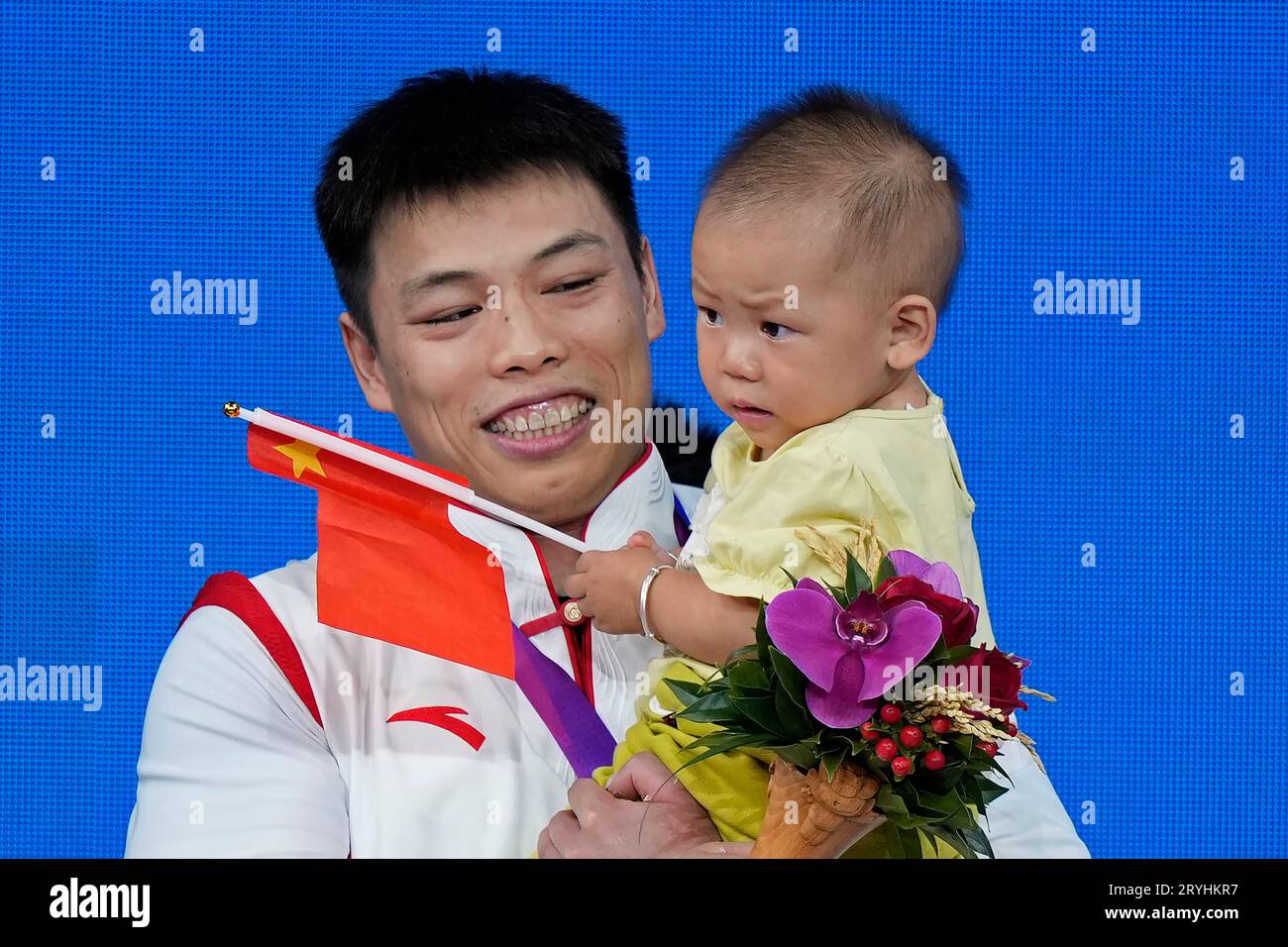 China's Lijun Chen carries his daughter on the podium after receiving ...