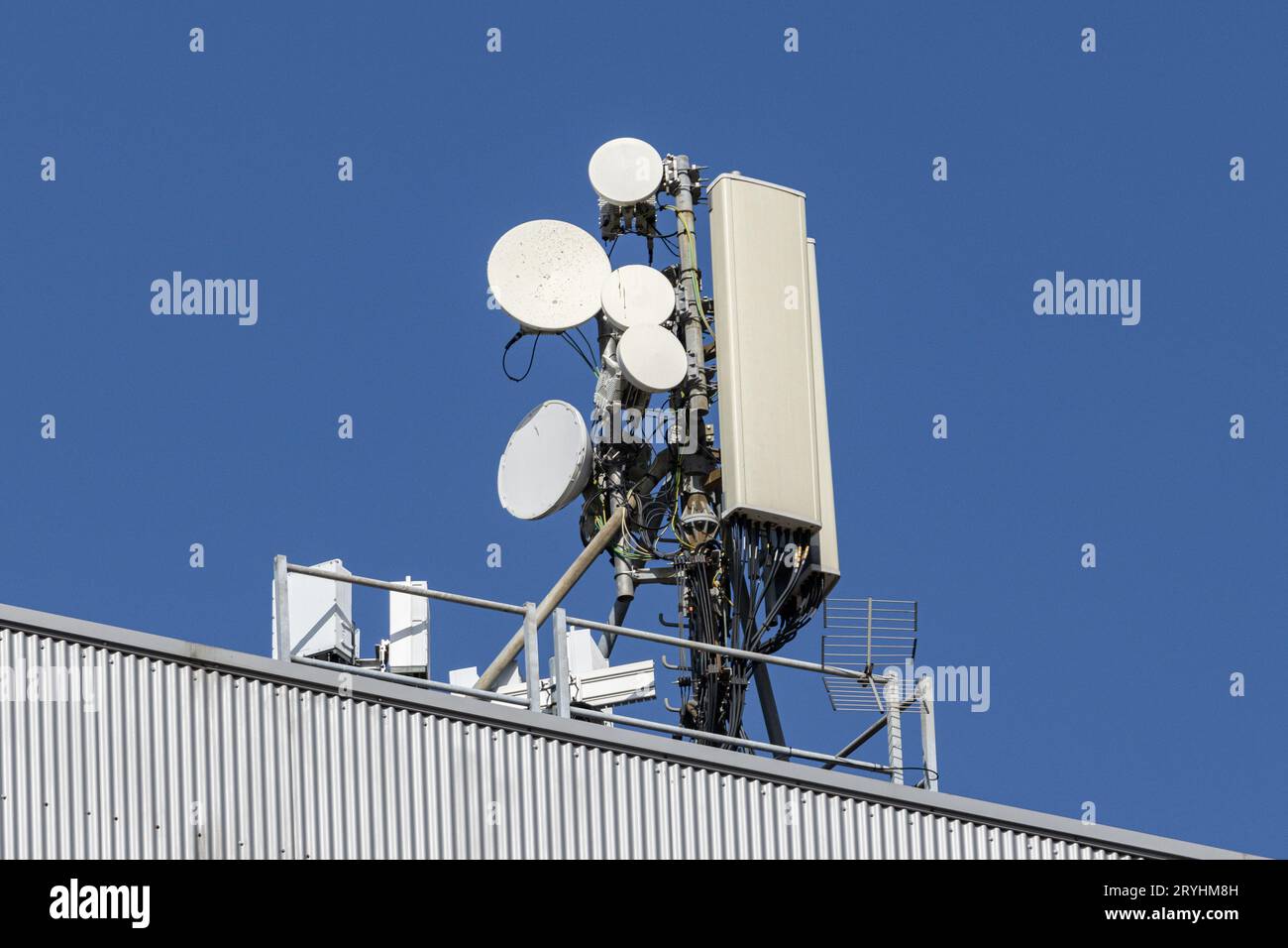 Telecommunication tower antenna of mobile communication system located on a rooftop building ...