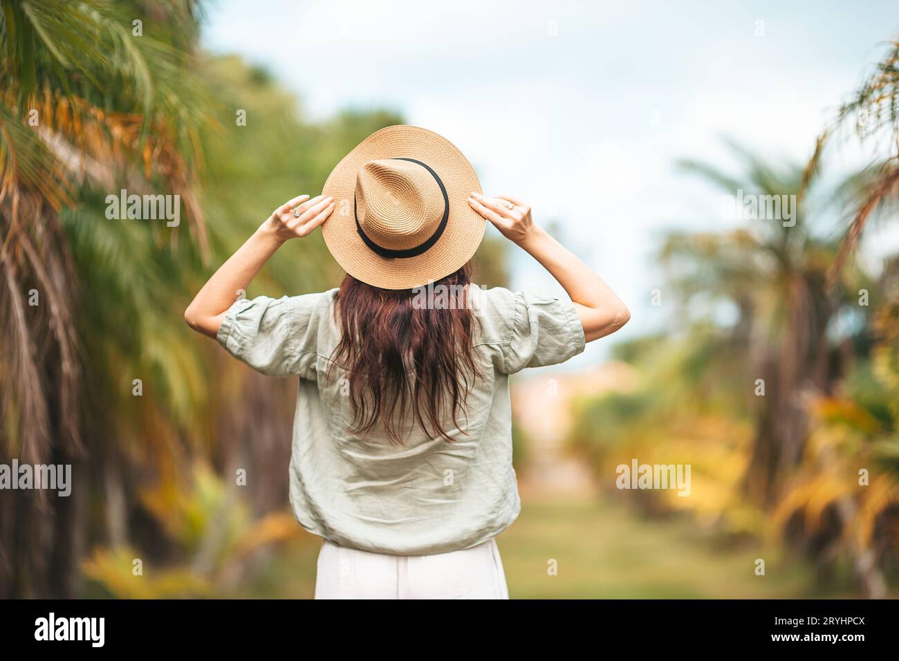 Back view of woman in straw hat outdoors among the palmtrees Stock ...
